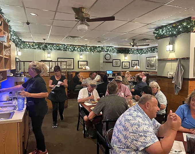 Inside, holiday greenery meets wood paneling in a dining room where conversations flow as freely as the sweet tea. No Instagram filters needed—this is authentic Ohio comfort.