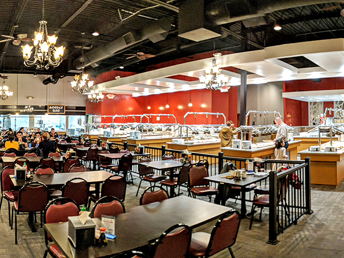 Elegant chandeliers hanging above a sea of tables create an unexpected touch of class. This isn't your average buffet—it's dinner theater with you as the star.