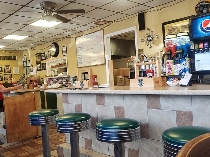 Classic diner counter seating with those unmistakable green vinyl stools – where solo diners become part of the Deer Creek family within minutes.