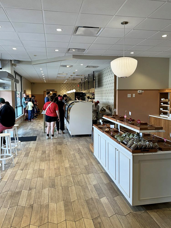 The line forms for good reason—this isn't just another bakery. Wood floors, paper lanterns, and display cases filled with edible art create a space worth waiting for.