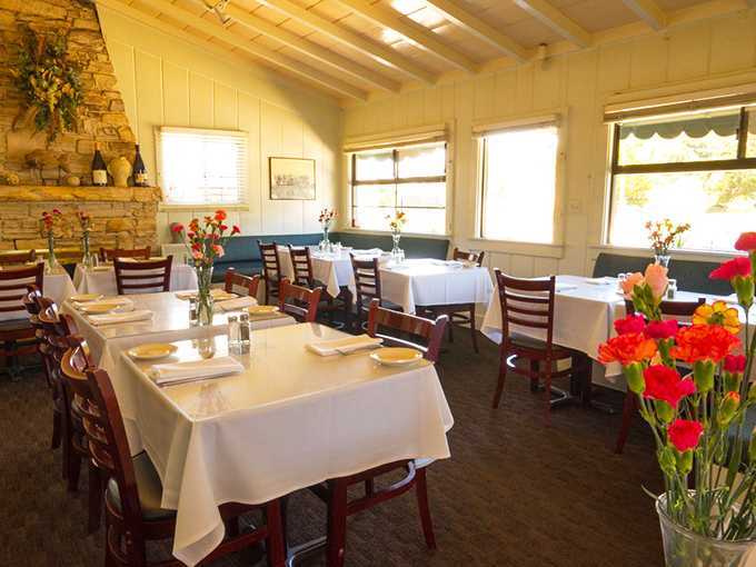 White tablecloths meet rustic charm in this dining room where fresh flowers add pops of color and conversations flow as freely as the wine.