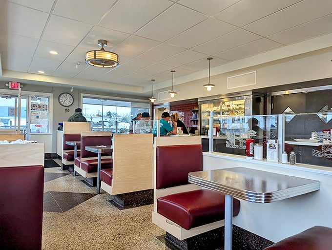 Classic burgundy booths and gleaming countertops—this isn't just retro-chic design, it's a time machine where calories don't count and coffee refills are infinite.