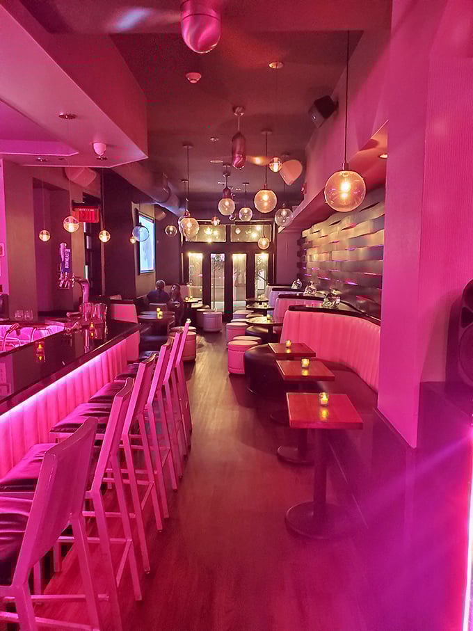 Step inside and you're bathed in a dreamy pink glow that makes everyone look like they're starring in their own music video. The pendant lights add just the right touch of drama.