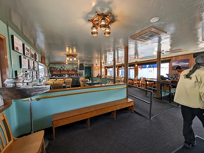 Nautical charm meets cozy comfort in this dining room where ship wheels and wooden beams aren't decorative choices—they're practically family heirlooms.