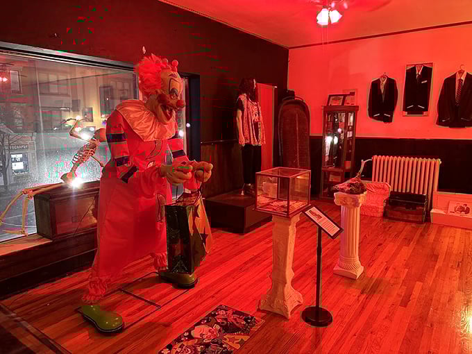 Bathed in blood-red lighting, this creepy clown figure isn't here to make balloon animals—unless they're anatomically correct heart balloons.