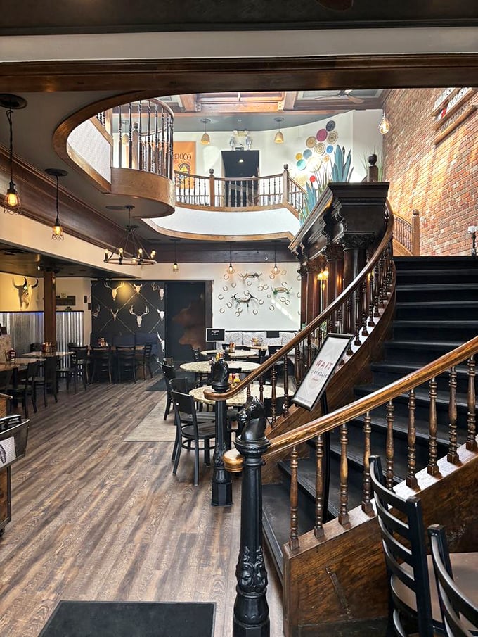 That staircase isn't just functional—it's architectural foreplay. The warm wood and exposed brick promise culinary delights await upstairs.