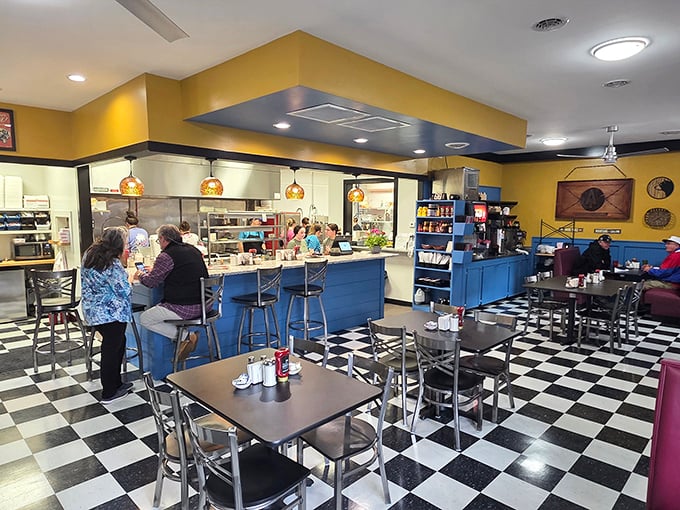 Classic black and white floors meet sunny yellow walls, creating that perfect diner atmosphere where conversations flow as freely as the coffee.
