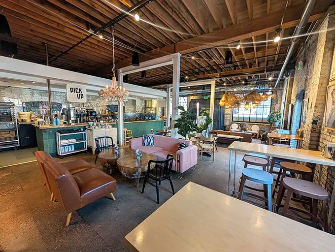 Industrial chic meets cozy comfort with that eye-catching pink couch serving as the restaurant's unofficial mascot. Exposed beams add rustic charm.