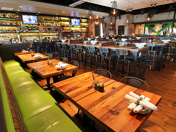 Where industrial meets cozy—Whiskey Cake's interior balances reclaimed wood tables, bright green banquettes, and a bar that beckons bourbon enthusiasts.