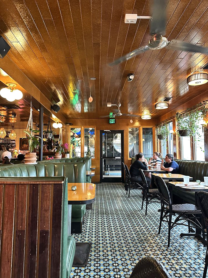 Warm wooden ceilings, patterned tiles, and green leather booths create the perfect mid-century tropical escape. Vacation vibes without the airfare!