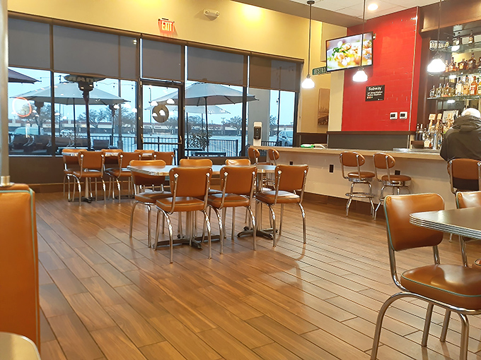 Classic orange vinyl chairs and warm wooden floors create that perfect diner atmosphere—nostalgic without trying too hard, like comfort food for your eyes.