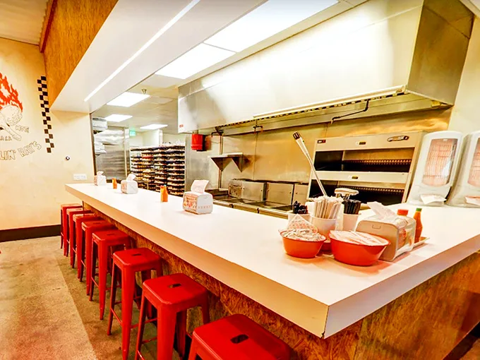 Simple red stools line the counter where culinary magic happens. No frills needed when the chicken speaks such volumes.