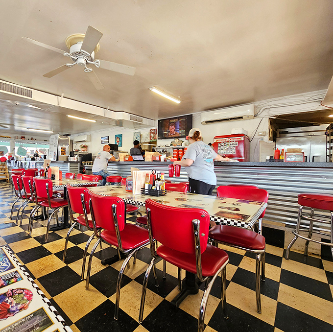 Classic Americana comes alive with red vinyl chairs, chrome tables, and that unmistakable black-and-white checkered floor—a time machine disguised as a diner.