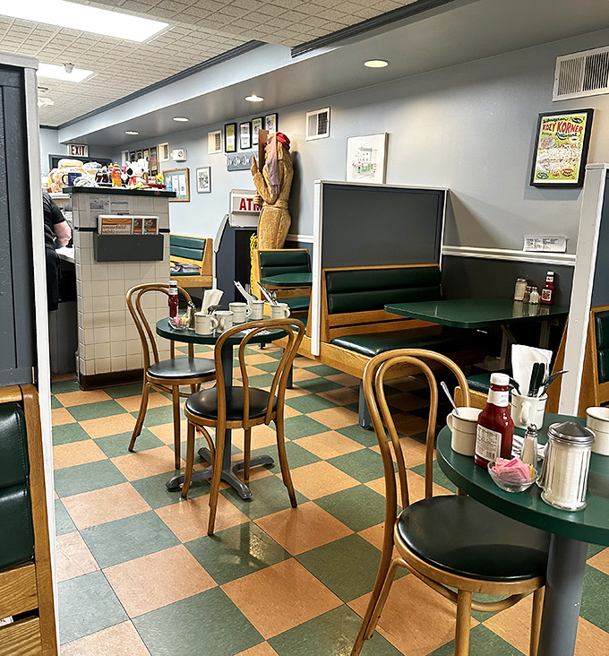Classic diner charm in full display—green vinyl booths, wooden chairs, and that iconic checkerboard floor where breakfast dreams come true.