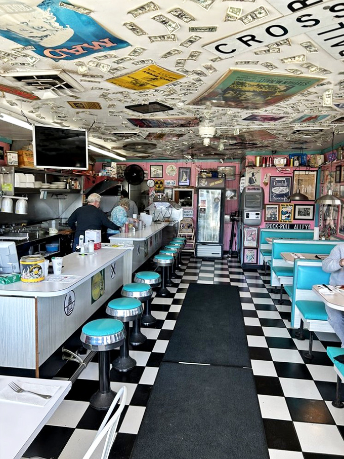 Step inside and the decades melt away – turquoise stools, checkered floors, and a ceiling plastered with memories. The 1950s called; they want you to stay awhile.