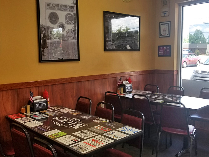 Tables adorned with local business cards under glass—the original social network. Yellow walls and wood paneling create that "come as you are" vibe.