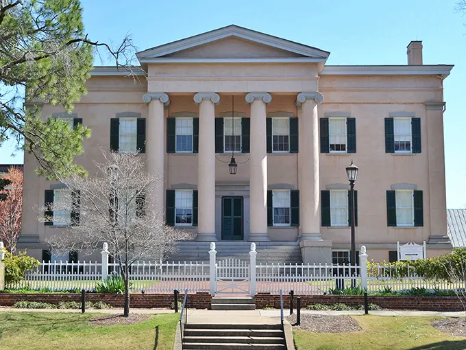 The Old Governor's Mansion stands as a testament to Greek Revival grandeur, its columns reaching skyward like architectural exclamation points declaring "History happened here!"