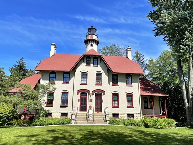 Victorian elegance meets nautical necessity in this cream-colored keeper's house with its distinctive red roof—architectural eye candy that tells a story of Great Lakes history.