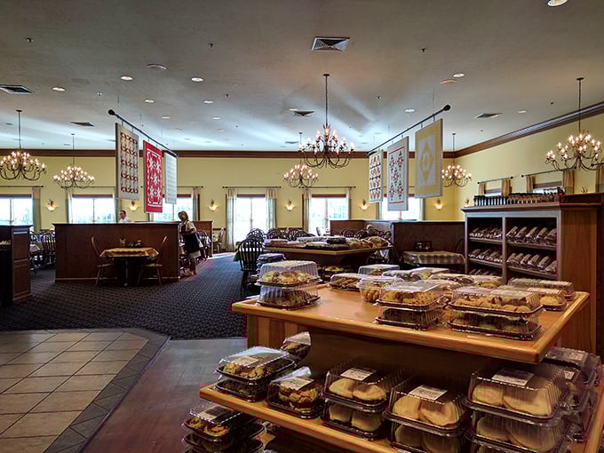 Handcrafted quilts hang like colorful sentinels over a dining room where the real treasures await – notice those take-home meals already prepped for hungry travelers.
