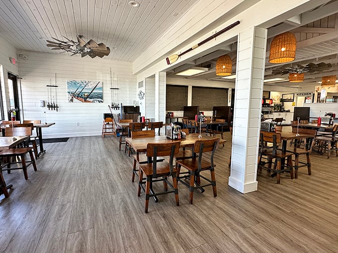 Bright white walls, wooden tables, and basket pendant lights create a casual coastal vibe that says "relax, you're about to eat something wonderful."