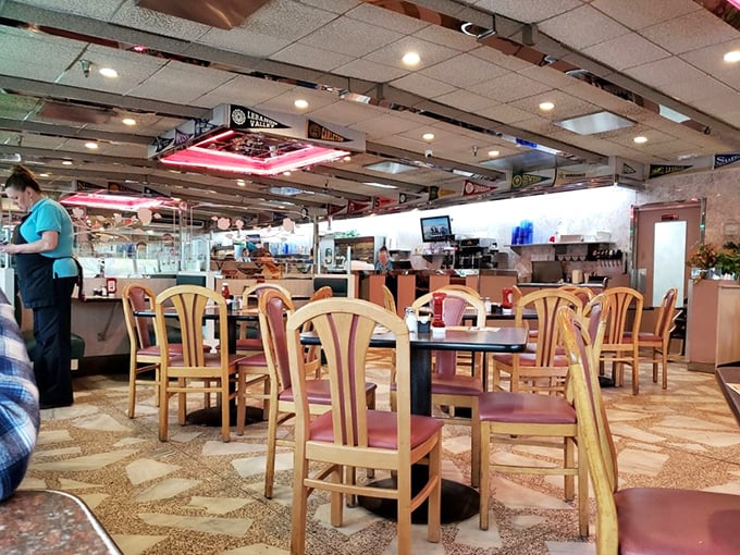 Classic diner ambiance with wooden chairs, terrazzo floors, and that unmistakable neon glow—where conversations flow as freely as the coffee refills.