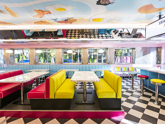 Stepping inside is like diving into a 1950s rainbow. Yellow and red booths pop against the checkerboard floor, while whimsical eggs float overhead.