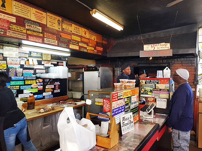 Where barbecue dreams come true – the ordering counter's wall of signs tells stories of countless satisfied customers and decades of smoky wisdom.