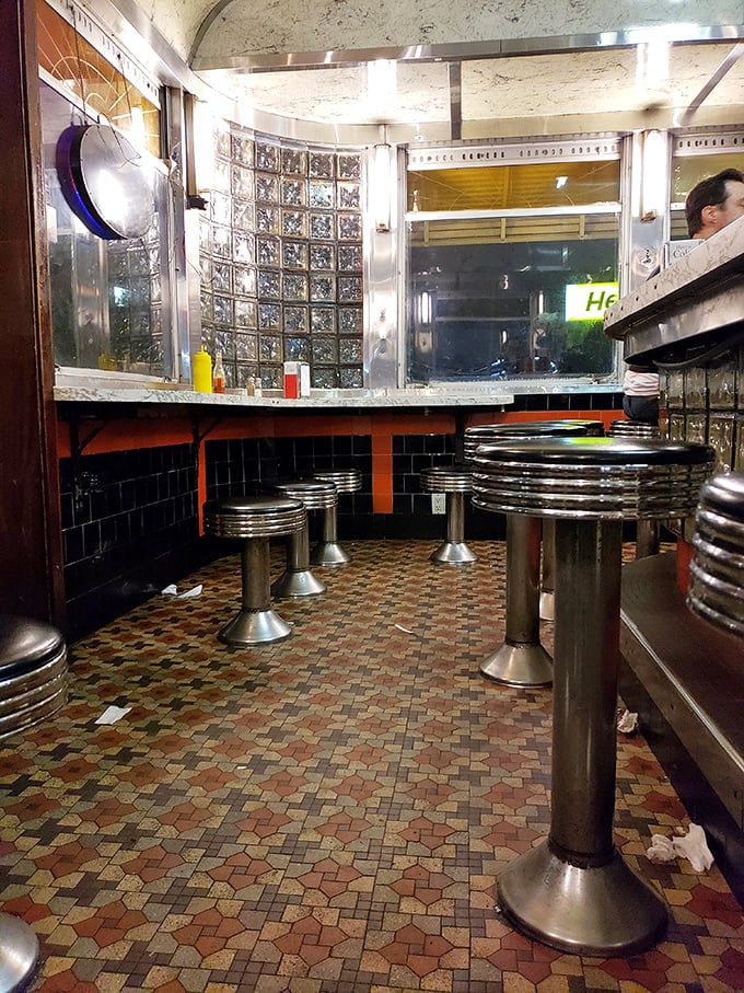 Counter culture at its finest—chrome stools, vintage tile floors, and a view of burger artistry that beats any five-star restaurant's chef's table.