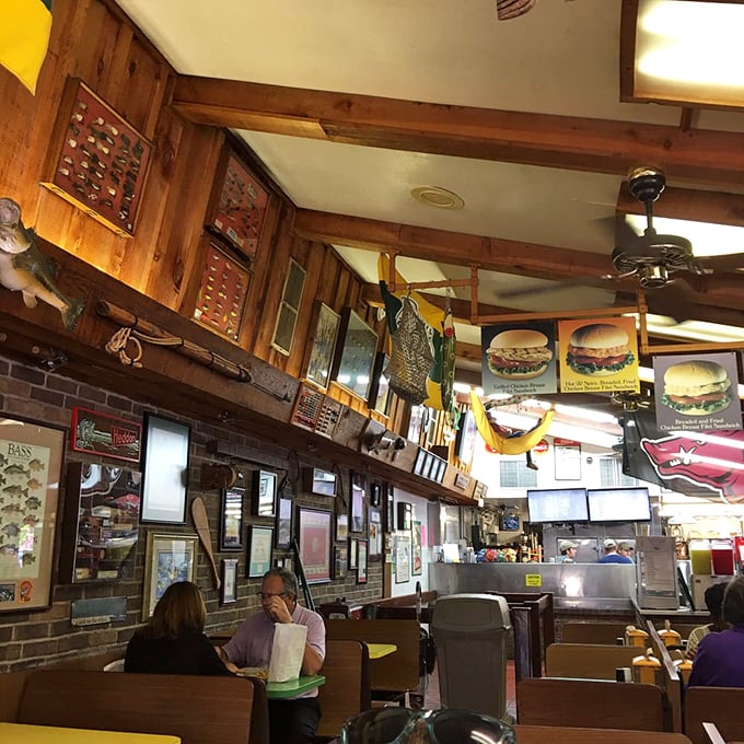 Wood paneling, fishing memorabilia, and burger photos create the perfect time capsule interior—where calories don't count and nostalgia flows freely.