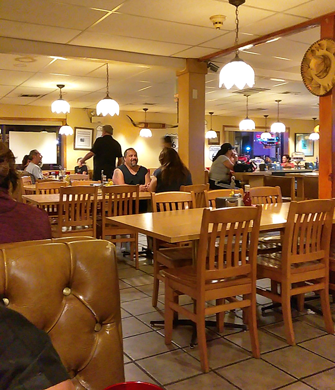 Pendant lights cast a warm glow over wooden tables where decades of conversations have unfolded—this isn't trendy ambiance, it's authentic New Mexico dining history.