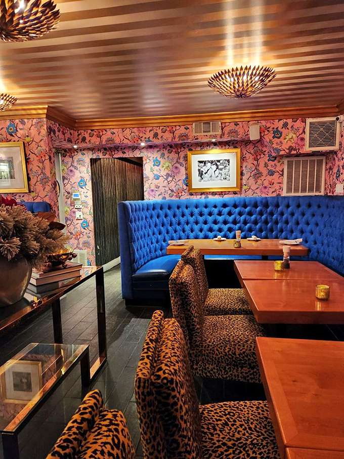 Step inside and discover a design fever dream where royal blue tufted booths meet leopard print seating and floral wallpaper. Somehow, it all works magnificently.