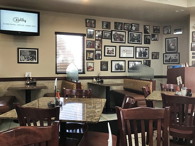 History lines these walls – decades of memories framed alongside diners creating new ones at granite-topped tables where magic happens daily.