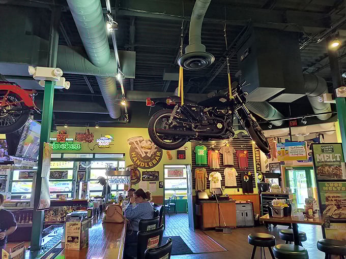 Dining under a motorcycle? Just another Tuesday at Quaker Steak & Lube, where automotive memorabilia transforms a meal into a full-throttle experience.