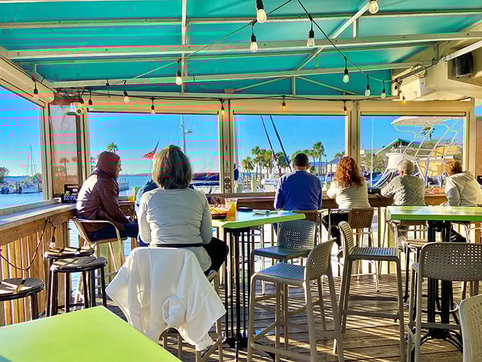 Front-row seats to nature's daily show. Diners soak in marina views under a turquoise canopy while boats gently bob in agreement.