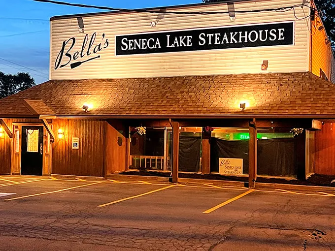 Bella's glows like a beacon for steak lovers at twilight. The wooden exterior promises rustic delights within.