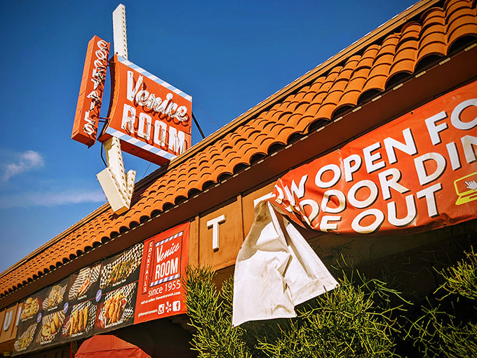 The Venice Room's neon sign glows like a beacon for hungry travelers. Cook-your-own-steak paradise awaits inside!