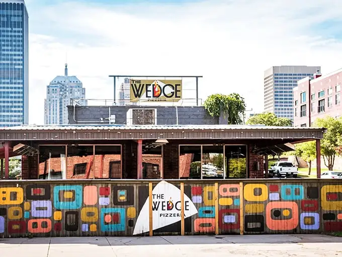 Colorful retro patterns dance across The Wedge's exterior. This isn't just a pizza place—it's a downtown landmark with serious pizza cred.