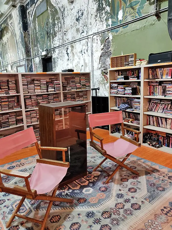 Literary treasures await the patient explorer. These pink director's chairs aren't just seating—they're front-row tickets to countless stories waiting on those packed shelves.