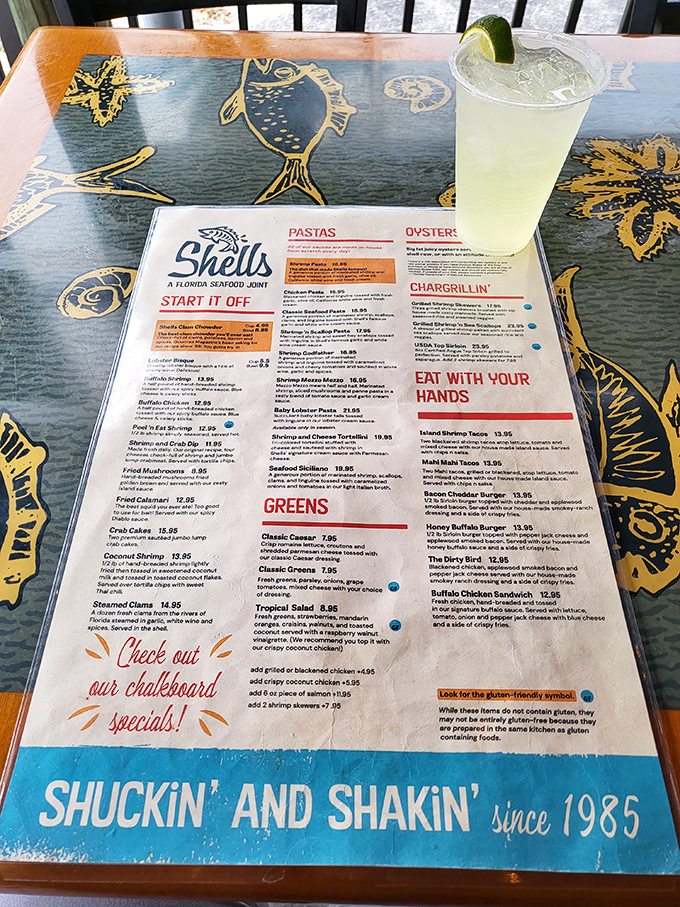 A menu that reads like a love letter to seafood, accompanied by what appears to be the perfect Florida afternoon refreshment. Decision paralysis has never been so delicious.