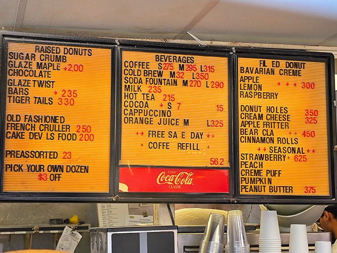 The menu board tells a story of donut possibilities, with the seasonal strawberry commanding top dollar—and worth every penny.