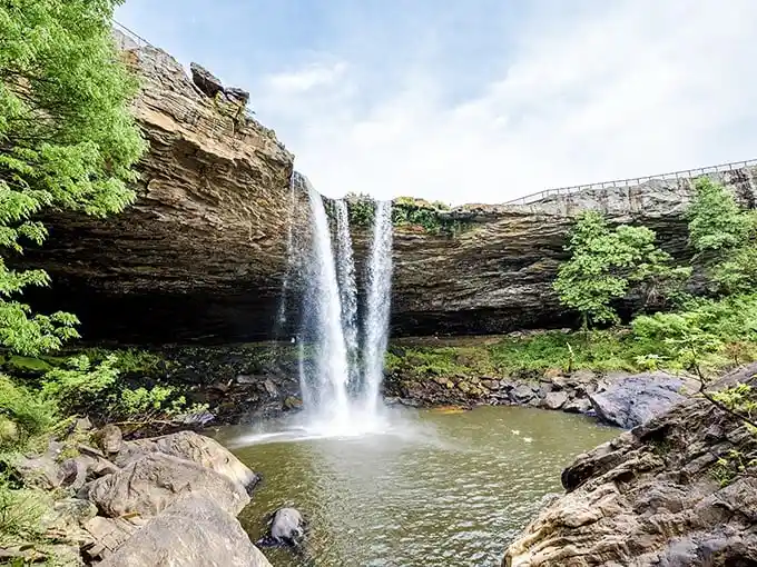 The falls from below reveal their true power – a thundering cascade carving through ancient stone, creating a natural amphitheater of mist and wonder.
