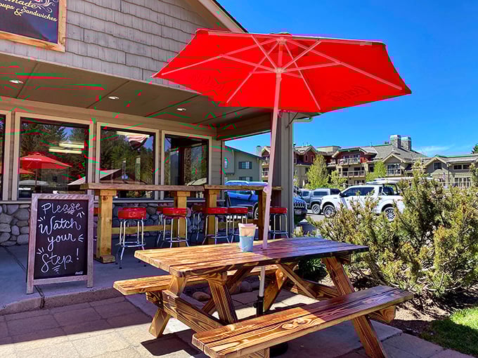 Nothing says "vacation mode activated" like a red umbrella and a wooden picnic table. This spot practically begs you to linger.