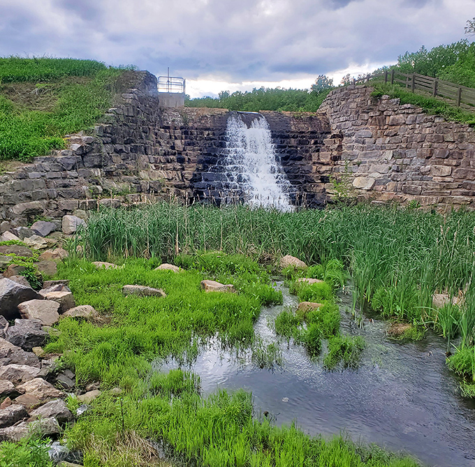 This historic stone dam waterfall doesn't just flow, it performs – nature's version of Broadway complete with dramatic cascades and verdant supporting cast.