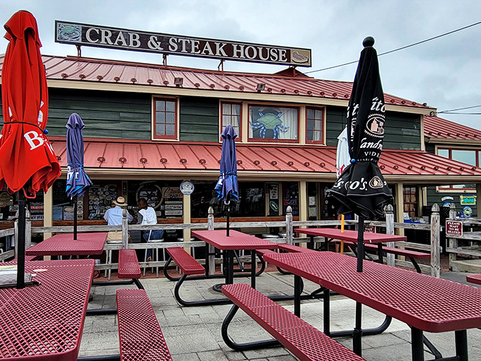 Nothing says "Chesapeake Bay dining" quite like red picnic tables, blue umbrellas, and a sign promising both crabs and steaks—the surf and turf of small-town dreams.