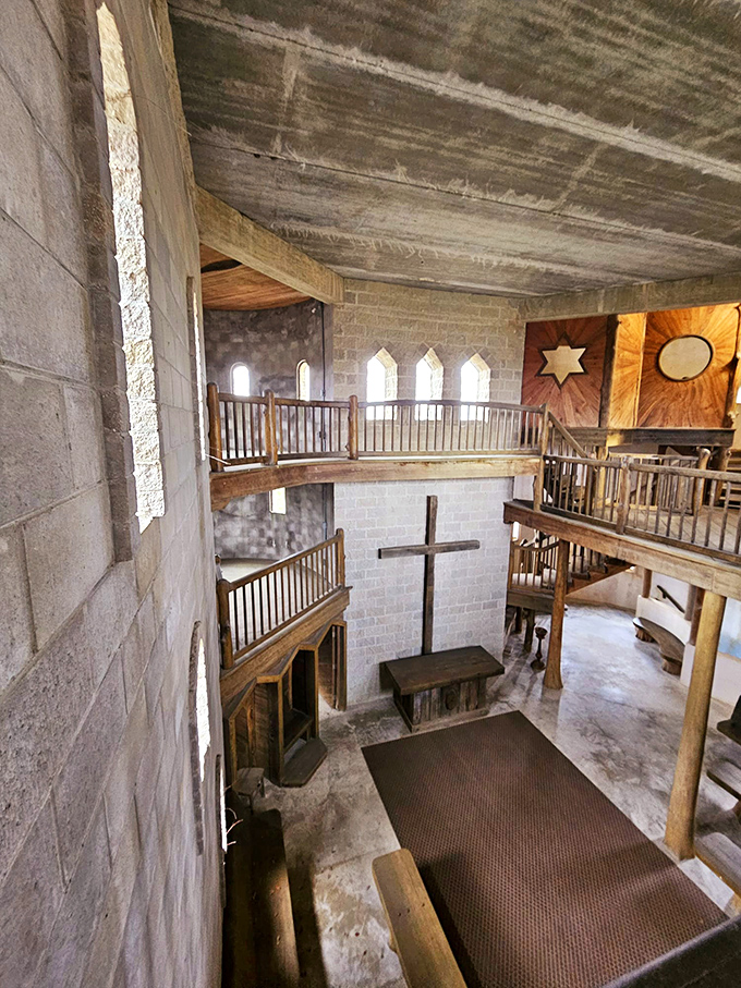 The interior reveals the castle's true purpose—a spiritual sanctuary where rustic wooden balconies frame a simple cross in contemplative silence.