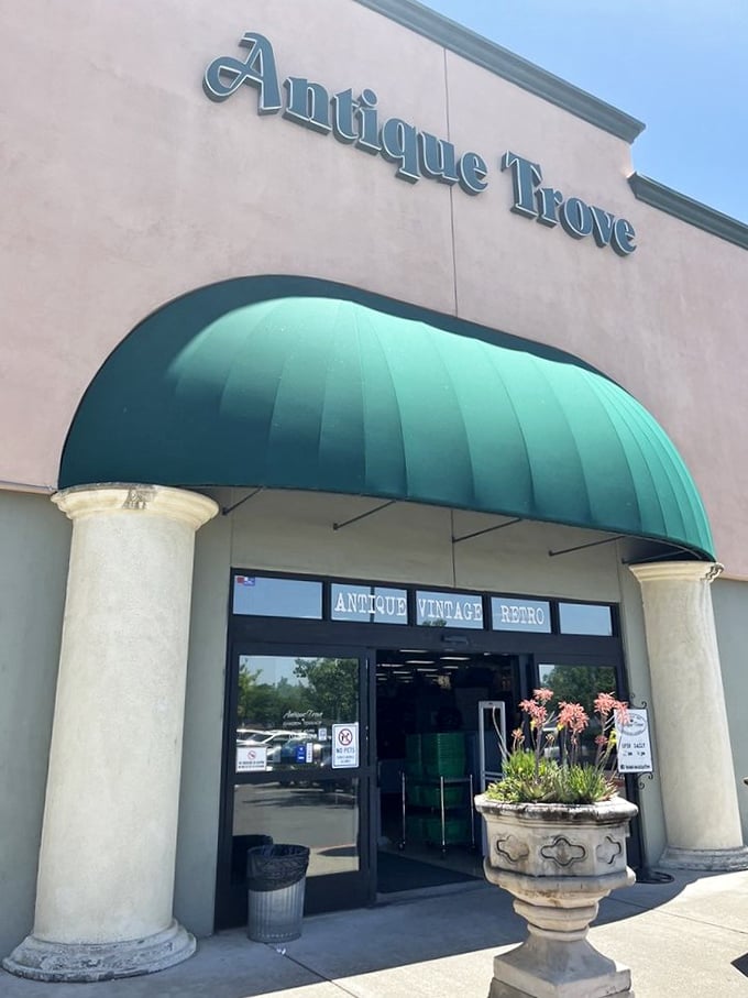 Antique Trove's grand entrance with teal awning and columns – where your wallet trembles but your heart sings.