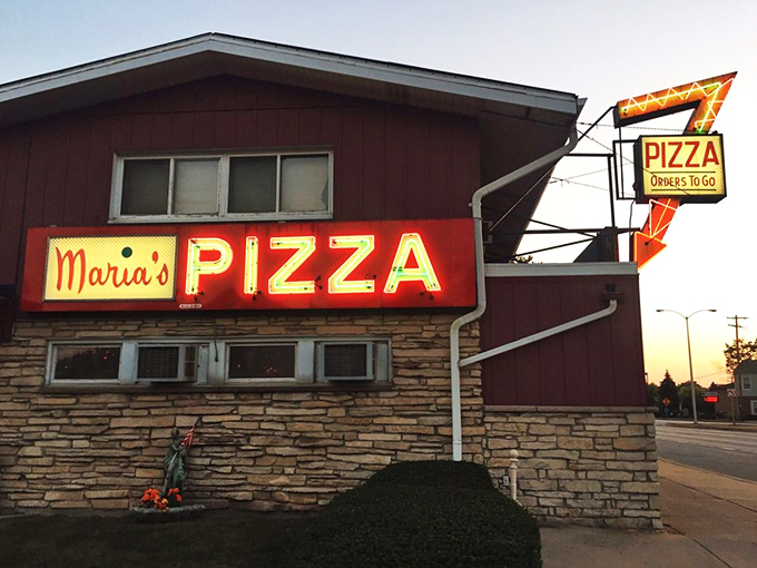 The neon arrow points to pizza nirvana. Maria's vintage charm is matched only by their massive oval pies. 