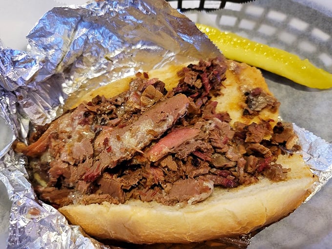 This brisket sandwich isn't just lunch—it's edible history. Tender meat surrenders to your bite while the pickle stands guard.