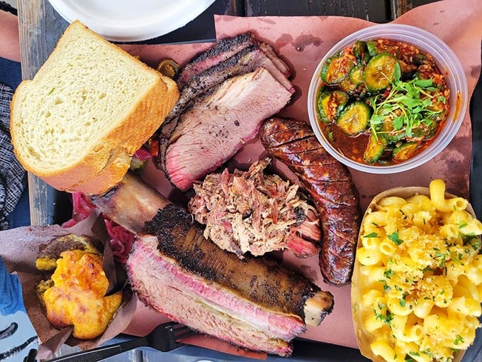 Meat paradise on pink butcher paper—where brisket, ribs, and pulled pork converge with mac and cheese that deserves its own ZIP code.
