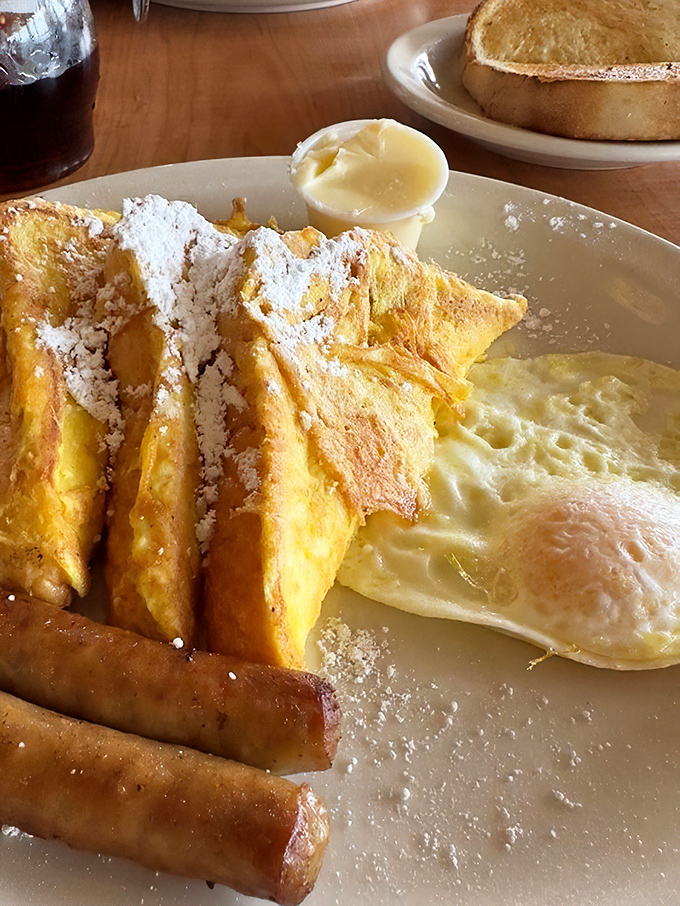 French toast dusted with powdered sugar like fresh Washington snow, alongside eggs cooked exactly how you asked—a morning miracle.